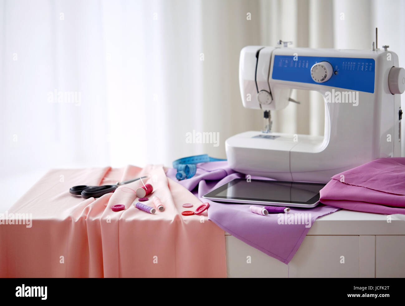 sewing machine, tablet pc, scissors and ruler Stock Photo - Alamy