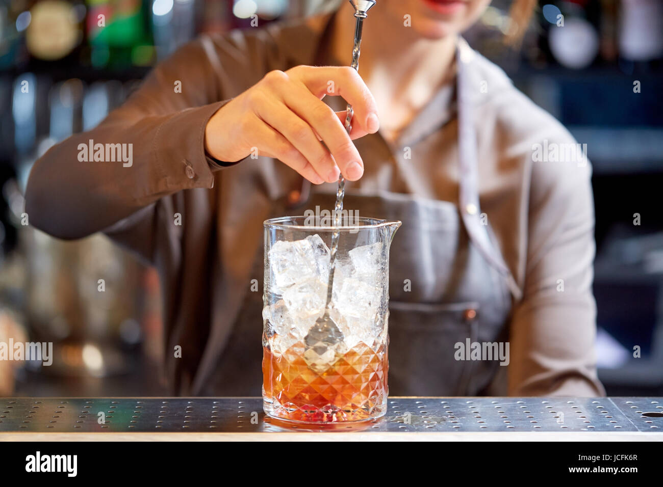 bartender with cocktail stirrer and glass at bar Stock Photo - Alamy