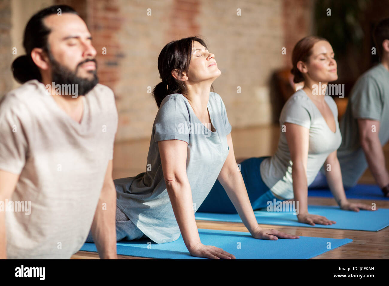 group of people doing yoga dog pose at studio Stock Photo - Alamy