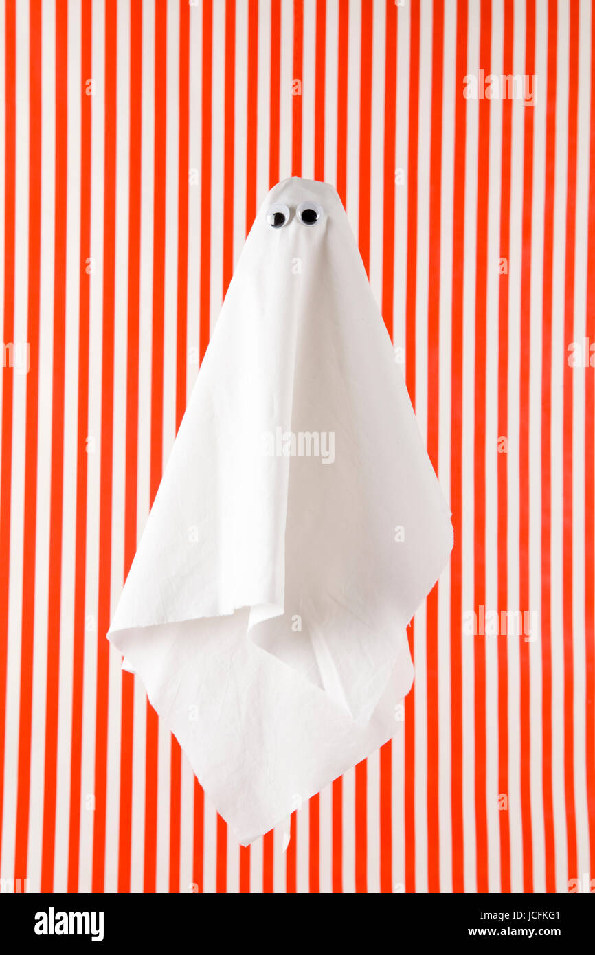 white sheet ghost with doll's eyes isolated on a striped background ...