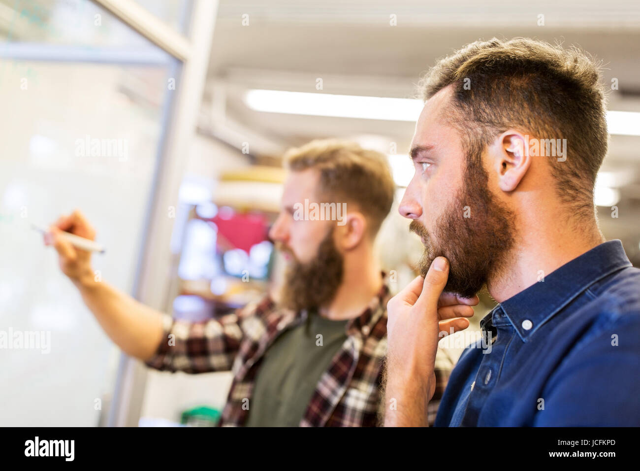 men writing to whiteboard at office Stock Photo - Alamy