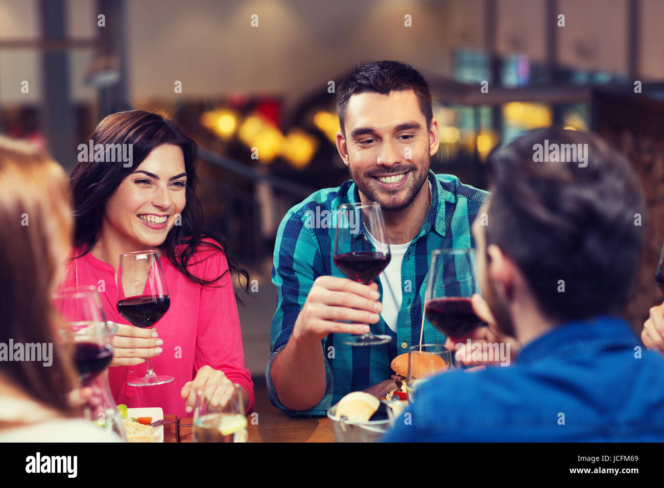 friends dining and drinking wine at restaurant Stock Photo - Alamy