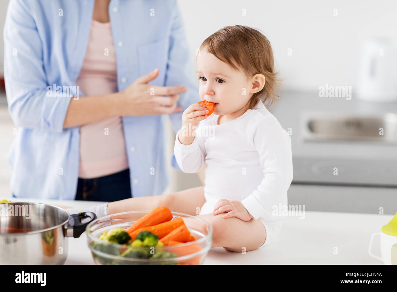 happy mother and baby eating at home kitchen Stock Photo - Alamy