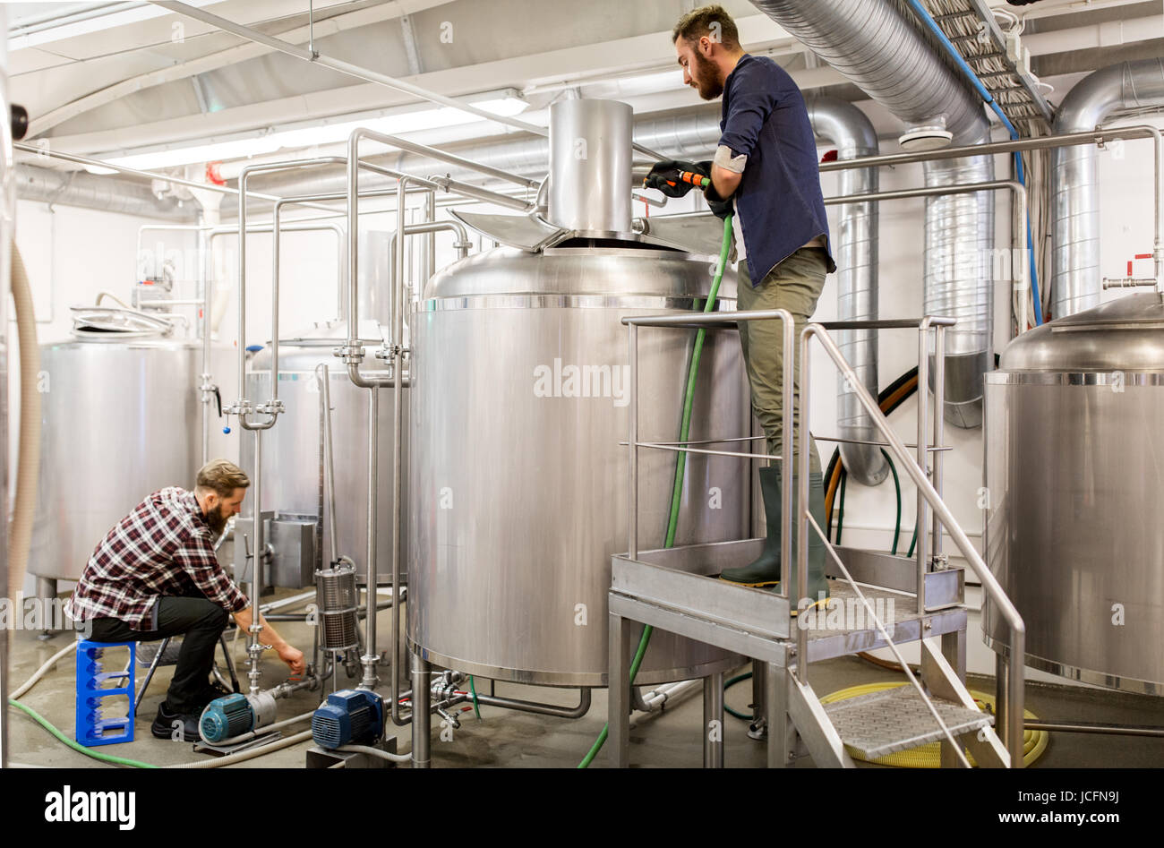 men working at craft beer brewery kettles Stock Photo - Alamy