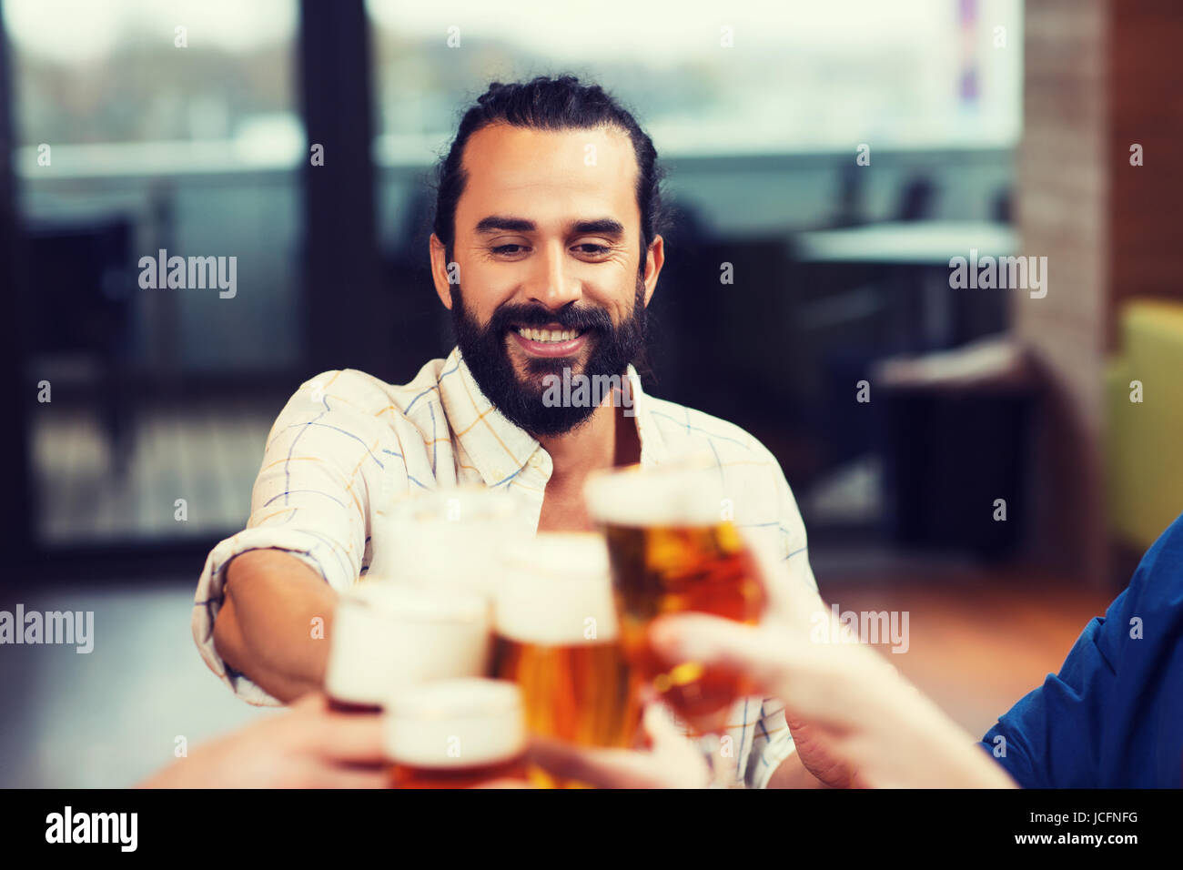 man clinking beer glass with friends at restaurant Stock Photo - Alamy