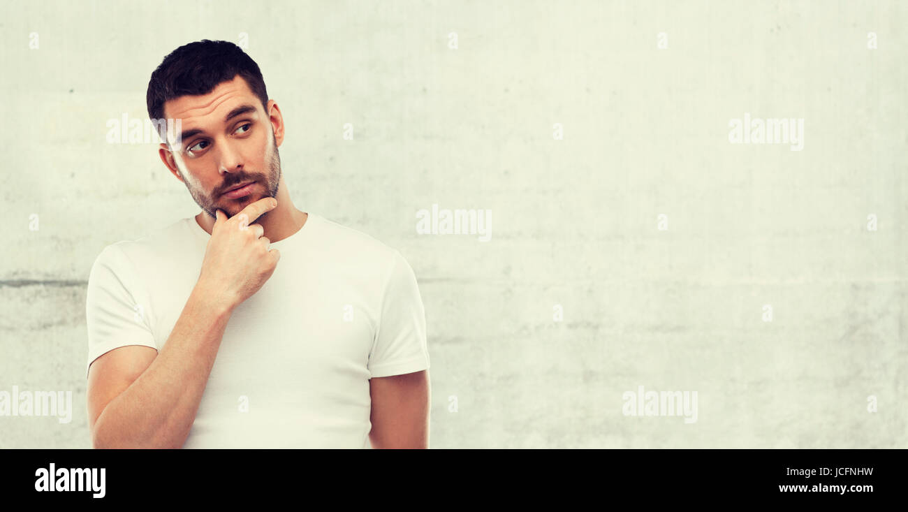 man thinking over gray wall background Stock Photo - Alamy