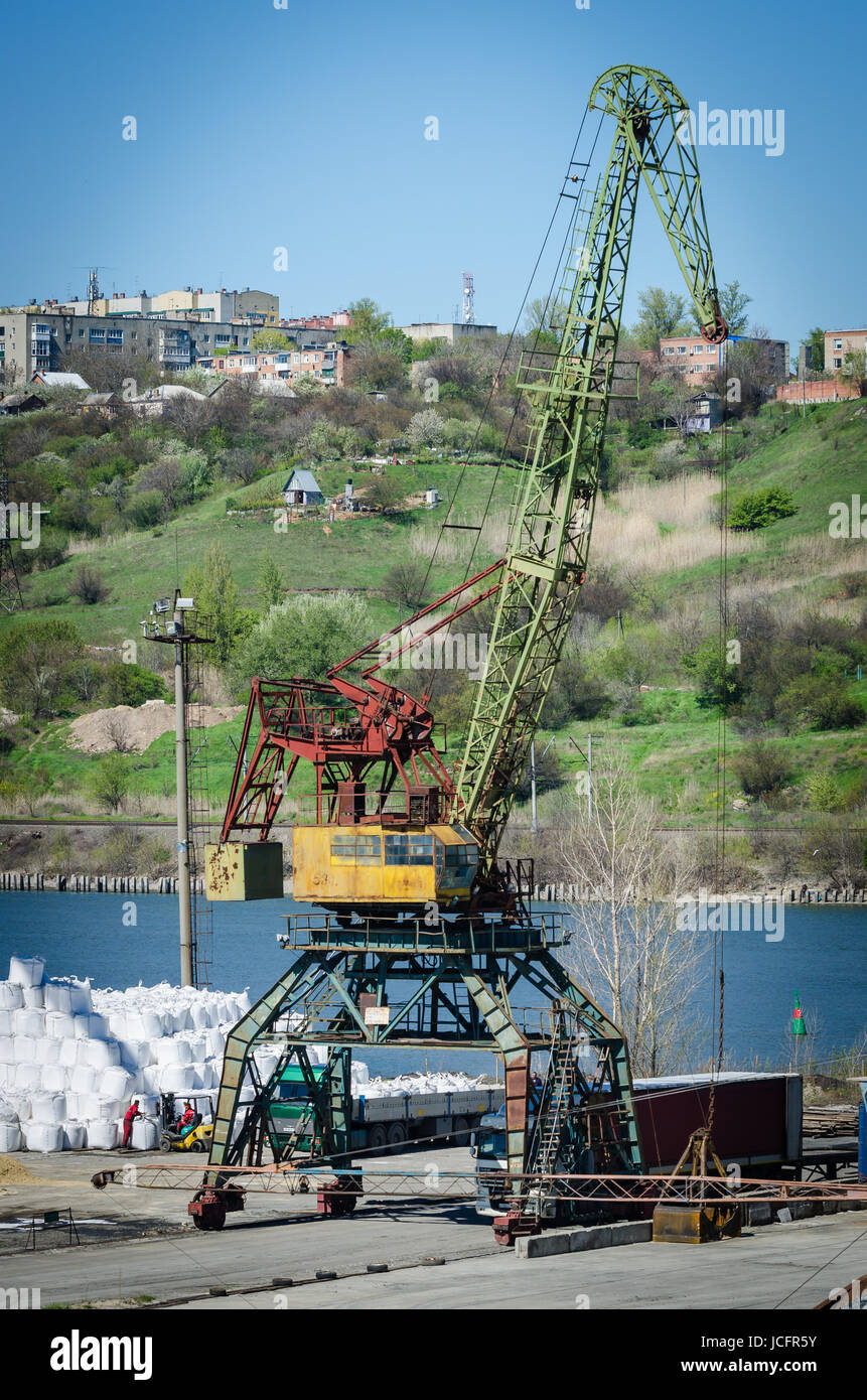 Crane in river port. Heavy cranes unloading metal to import. Steel ...