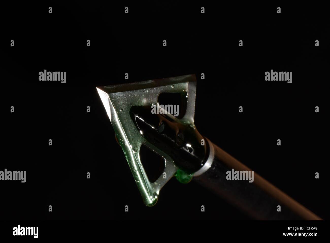 Poison arrow on black background. Metal arrowhead dripping green poison ...