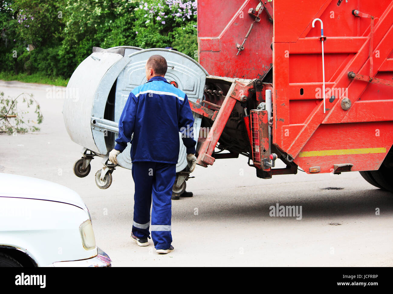 worker loads rubbish bin at a recycling machine Stock Photo - Alamy