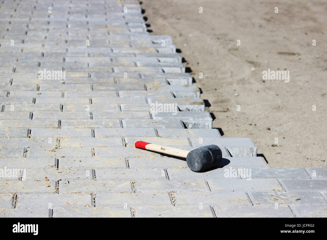 A professional hammer for fitting paving slabs to each other Stock ...