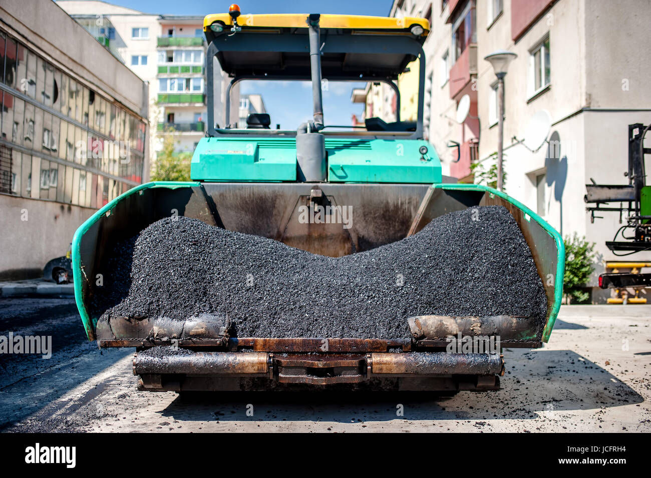 industrial paver laying fresh asphalt and bitumen pavement on top of ...