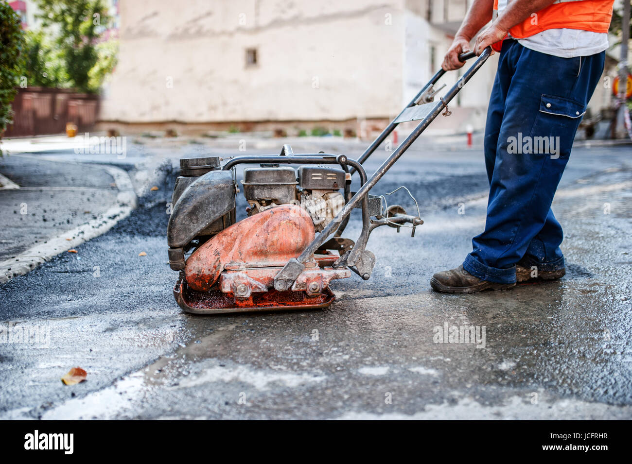 asphalt worker at road repairing with manual compactor plate Stock ...