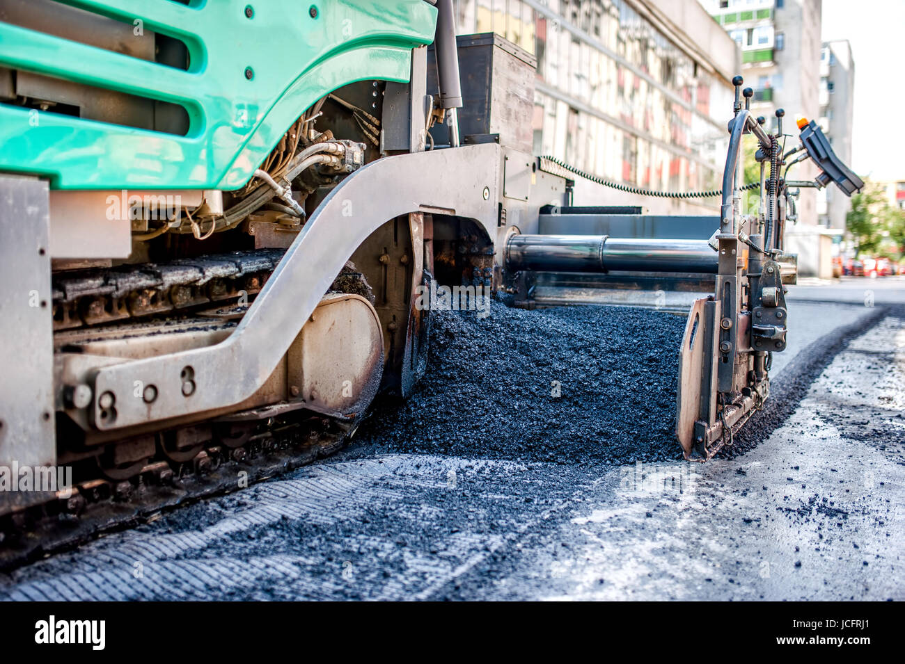 industrial truck laying fresh bitumen and asphalt at road construction ...