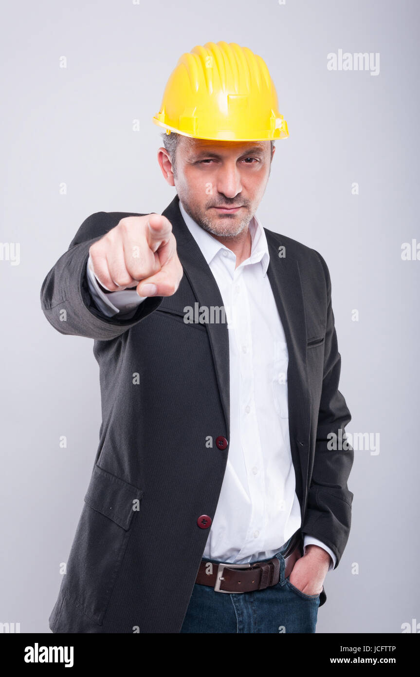 Portrait of foreman wearing hardhat pointing camera looking serious on ...