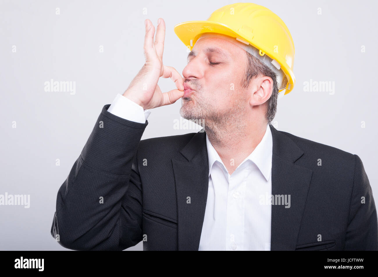 Portrait of handsome engineer making perfect gesture kissing fingers on ...