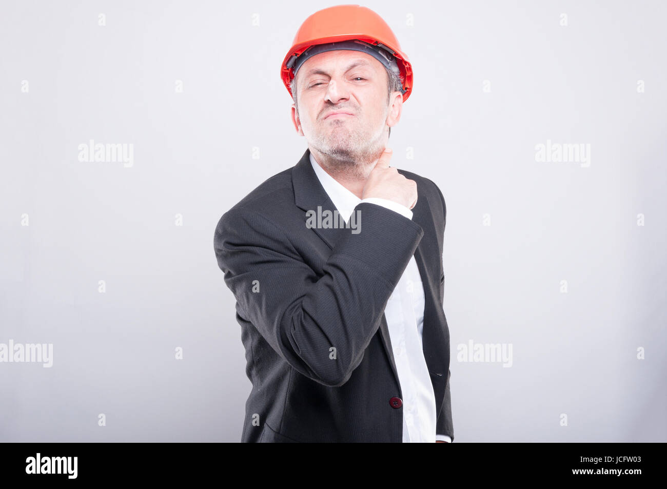Angry contractor wearing hardhat making cutting neck gesture on grey ...