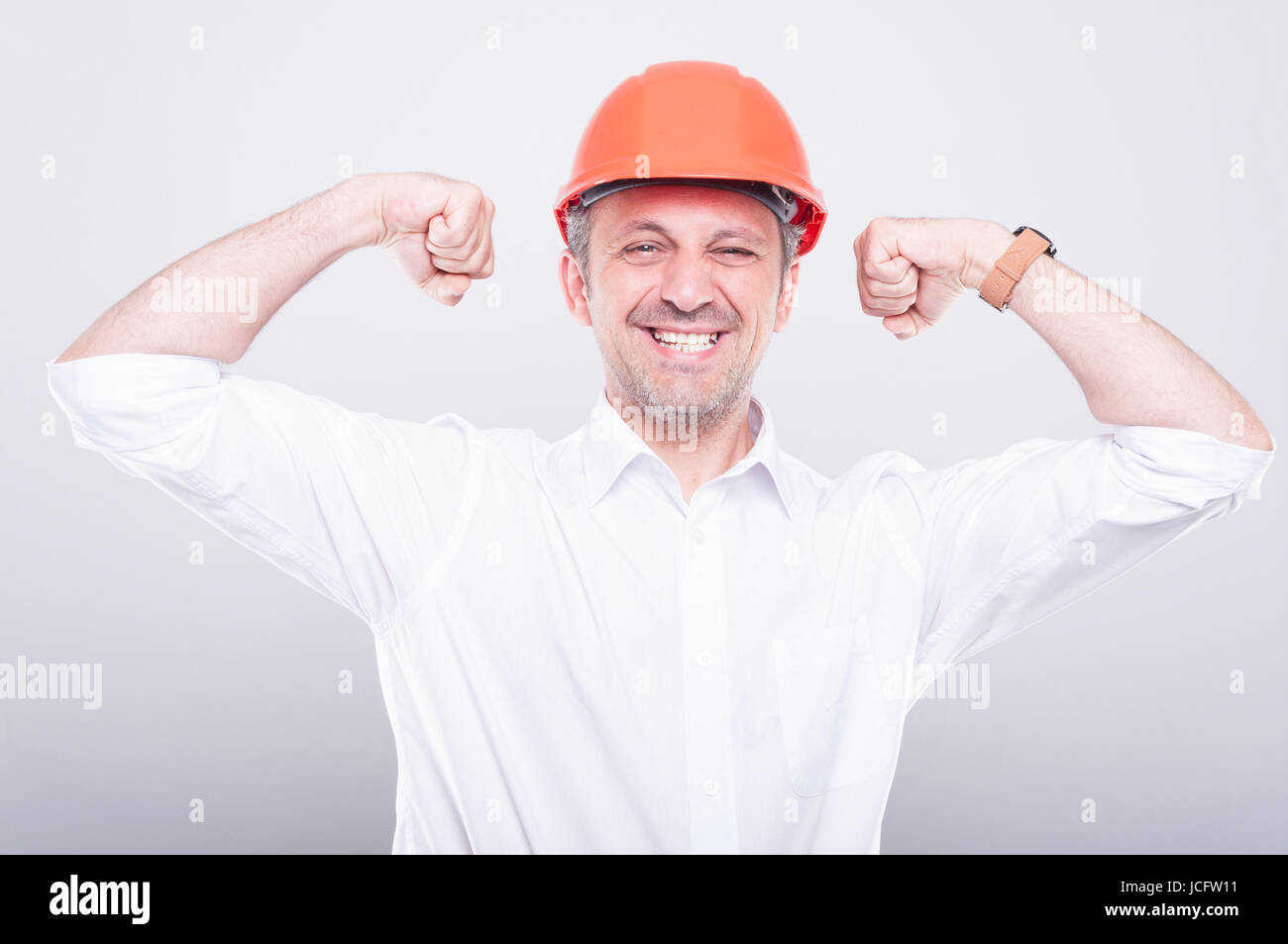 Portrait of architect wearing hardhat posing showing biceps like being ... Portrait of architect wearing hardhat posing showing biceps like being ...