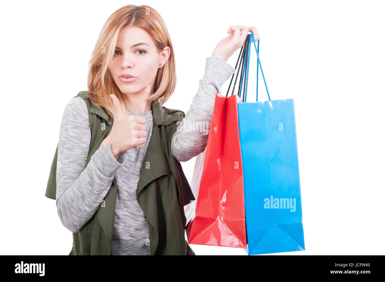 Beautiful female carrying colorful shopping bags and doing like gesture ...