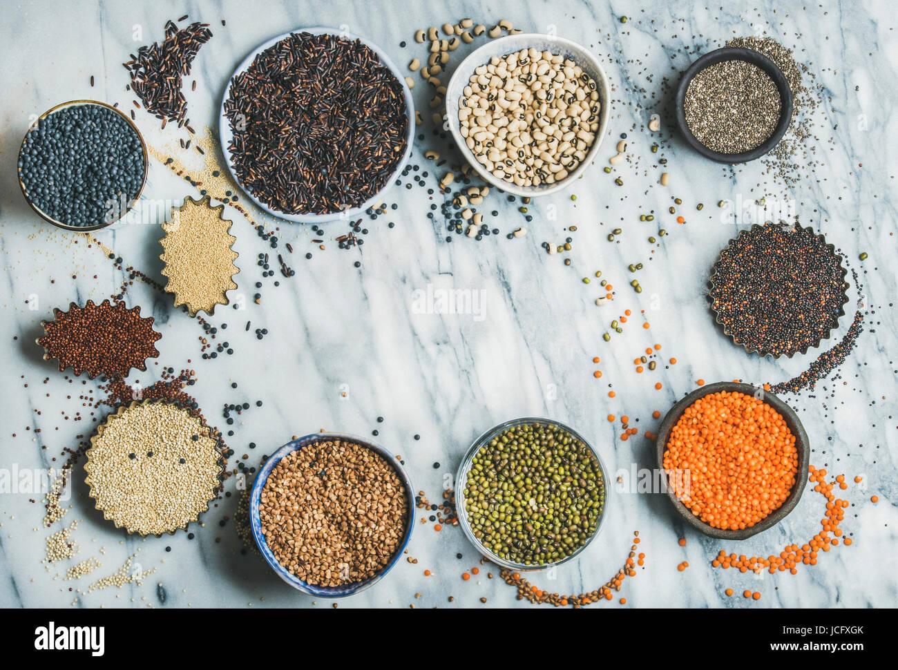 Various raw uncooked grains, beans, cereals in bowls and cups for ...