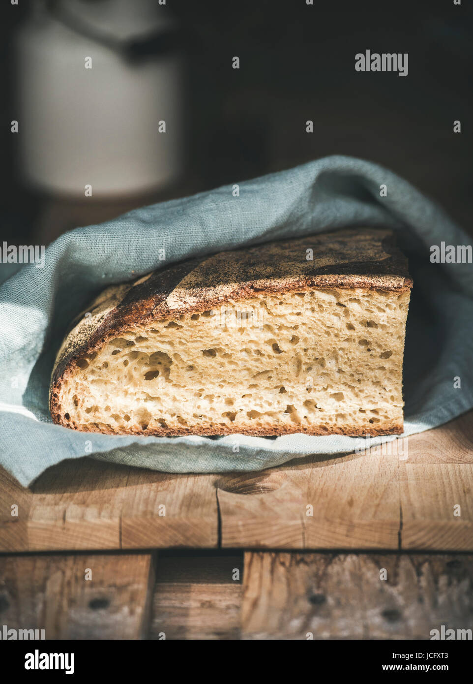 Rustic French rye bread loaf covered with kitchen towel over shabby ...