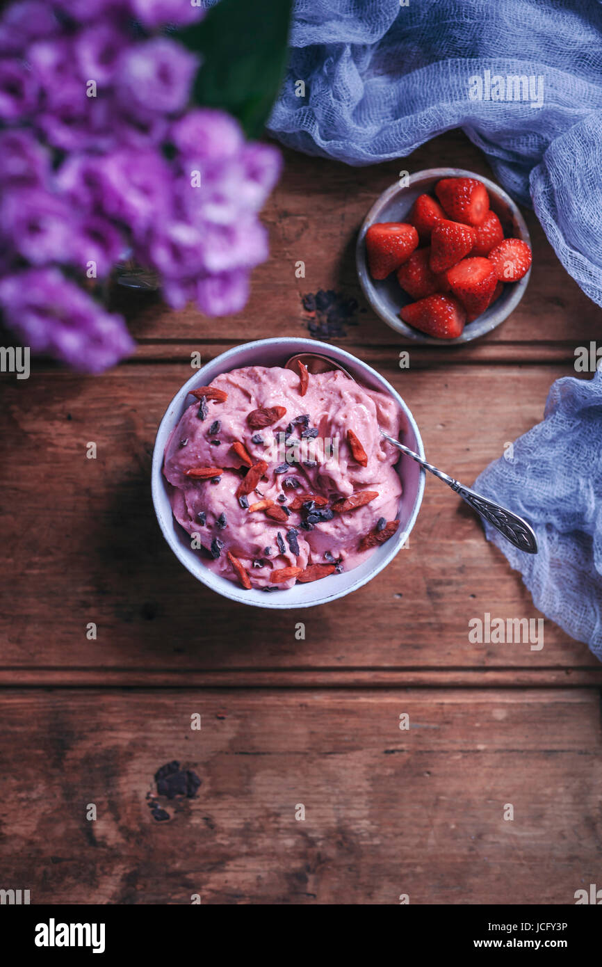 Strawberry banana ice cream in a bowl topped with goji berries and ...