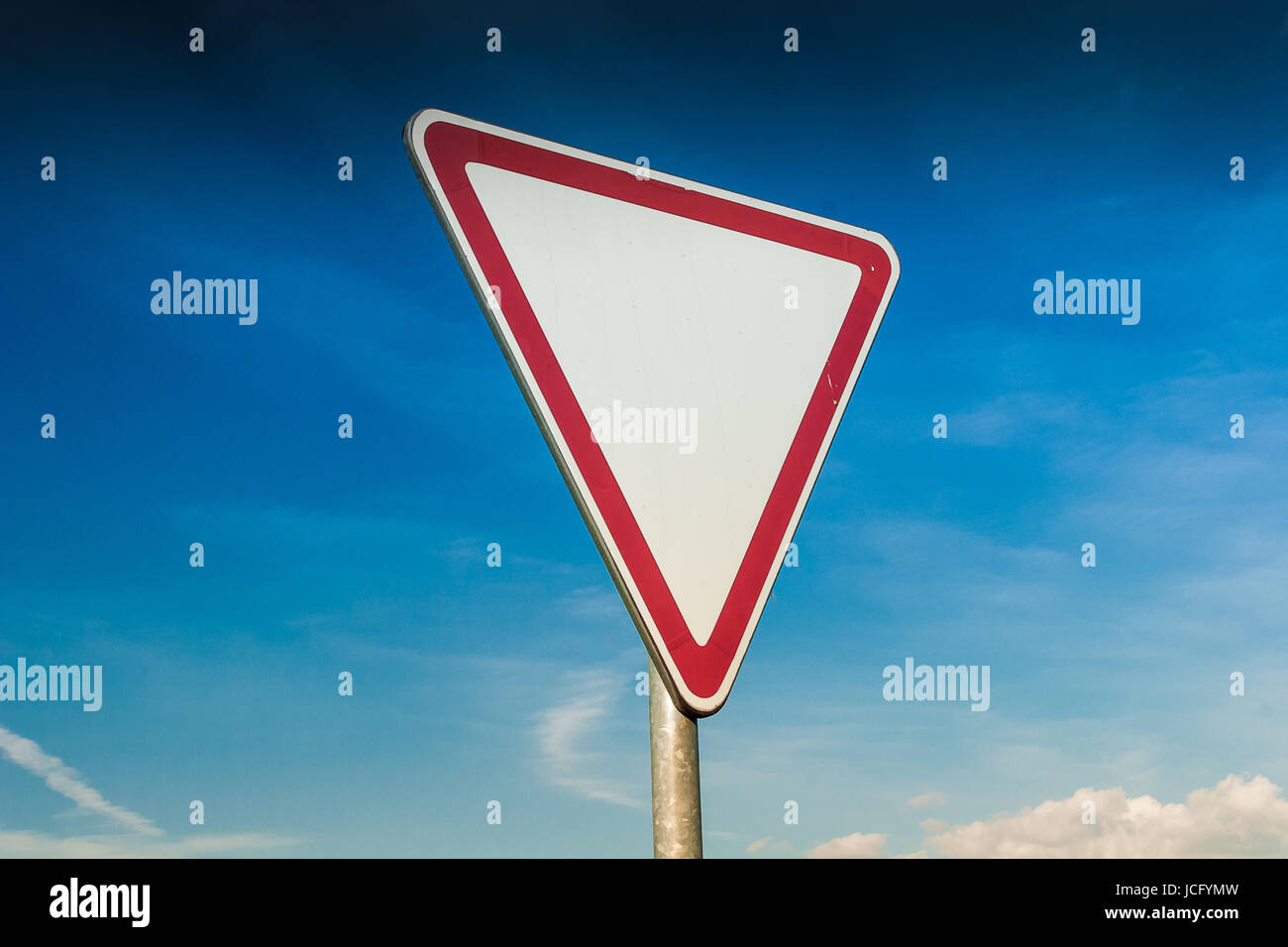 Yield - Give a way sign against blue sky Stock Photo - Alamy