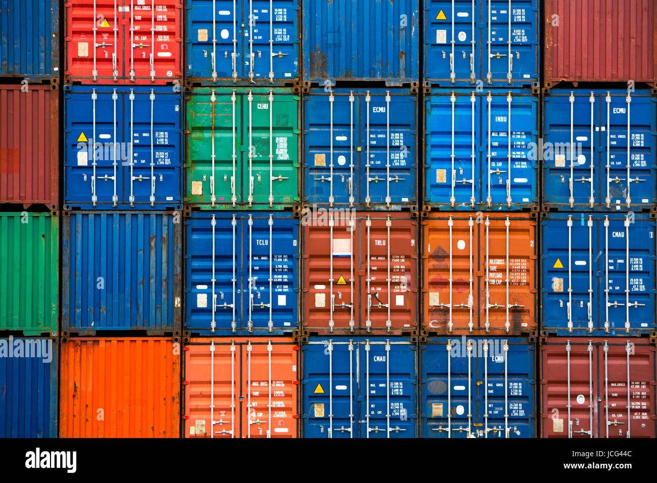 Four vertical rows of shipping containers that are different colors in ...