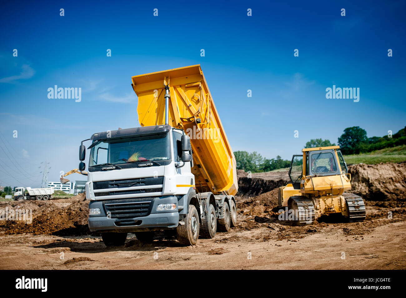 dumper truck and bulldozer at highway road construction site Stock ...
