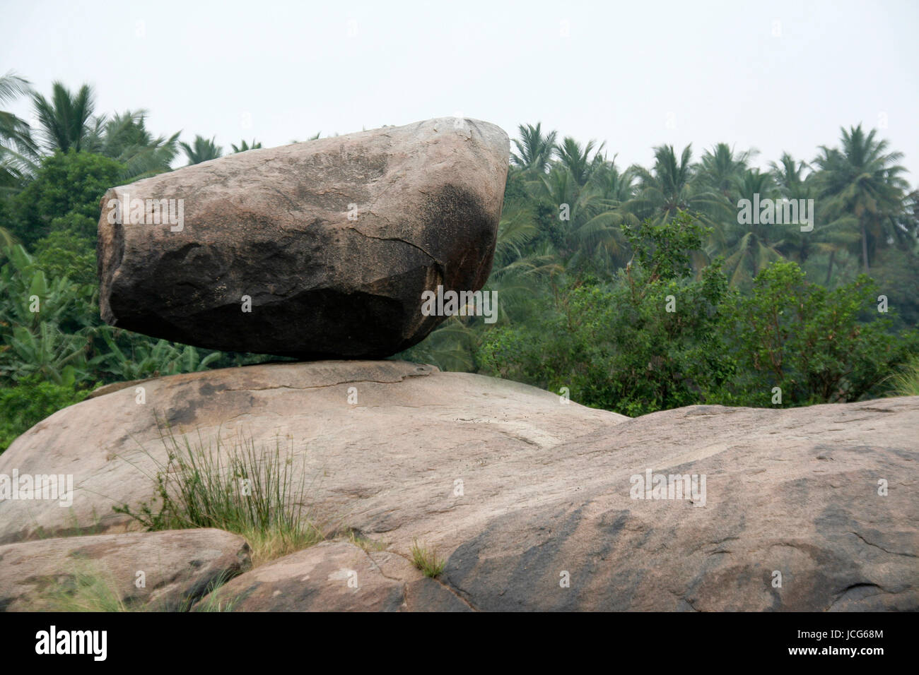 Barrel shaped boulder resting on bed of rock Stock Photo - Alamy