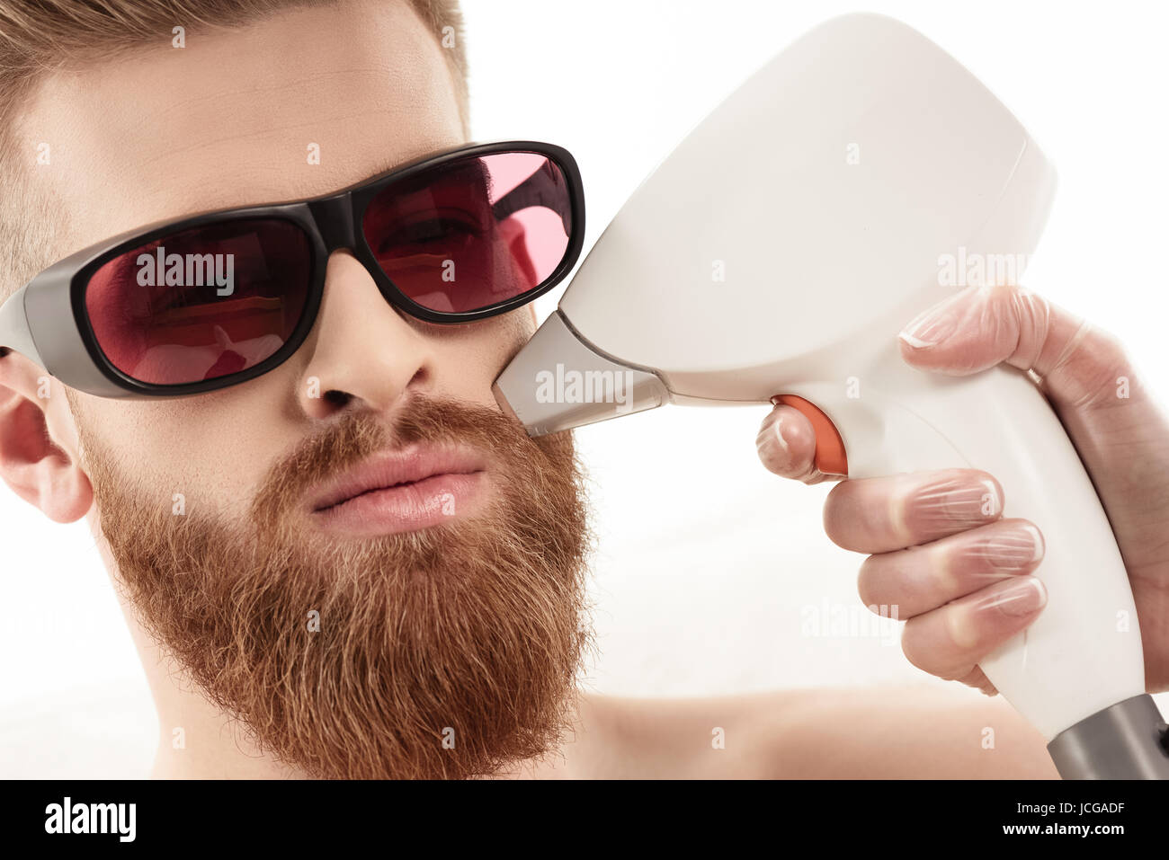 young man receiving laser skin care on face isolated on white. healthy ...