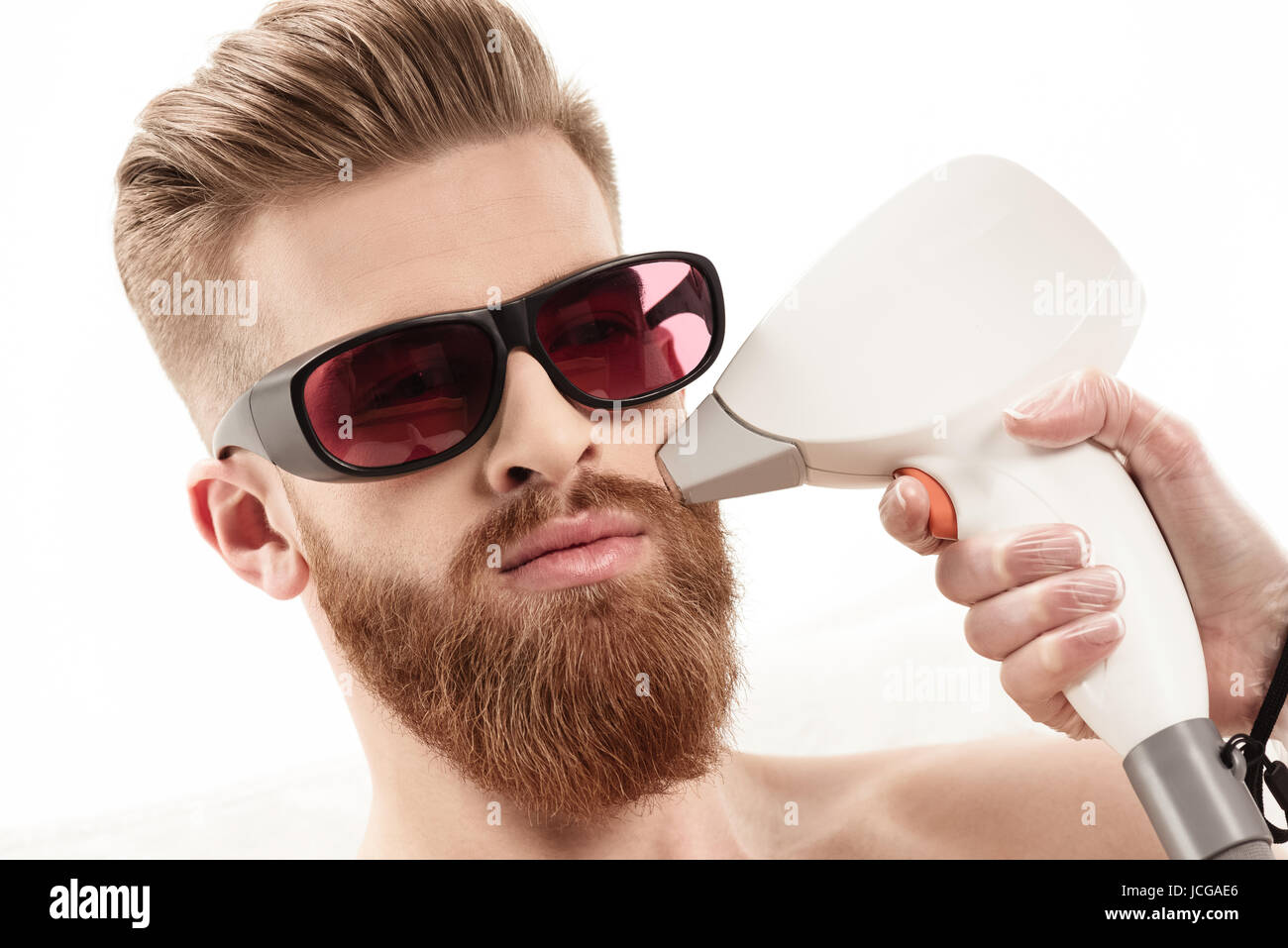 young man receiving laser skin care on face isolated on white. healthy ...