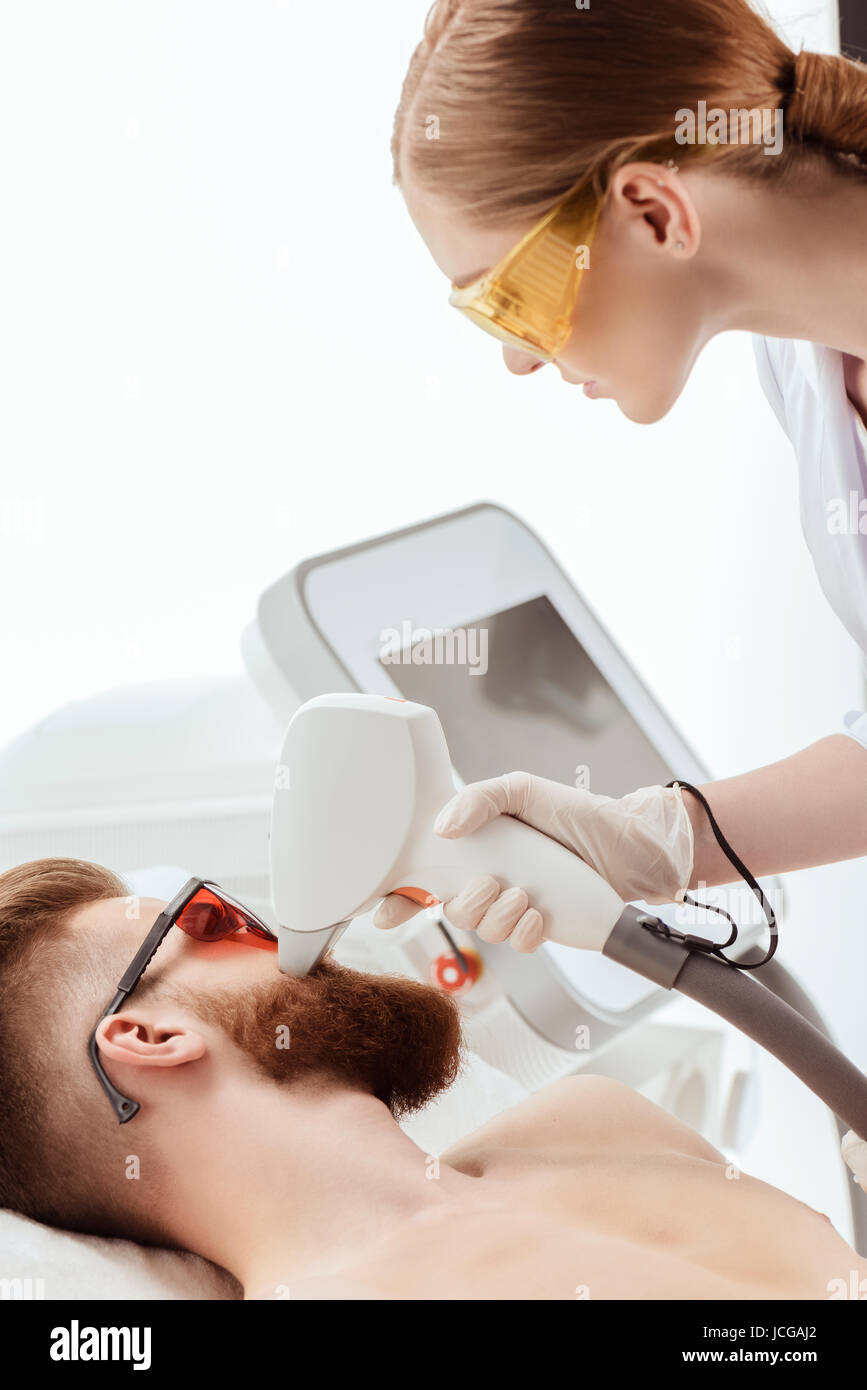 young man receiving laser skin care on face isolated on white. healthy ...
