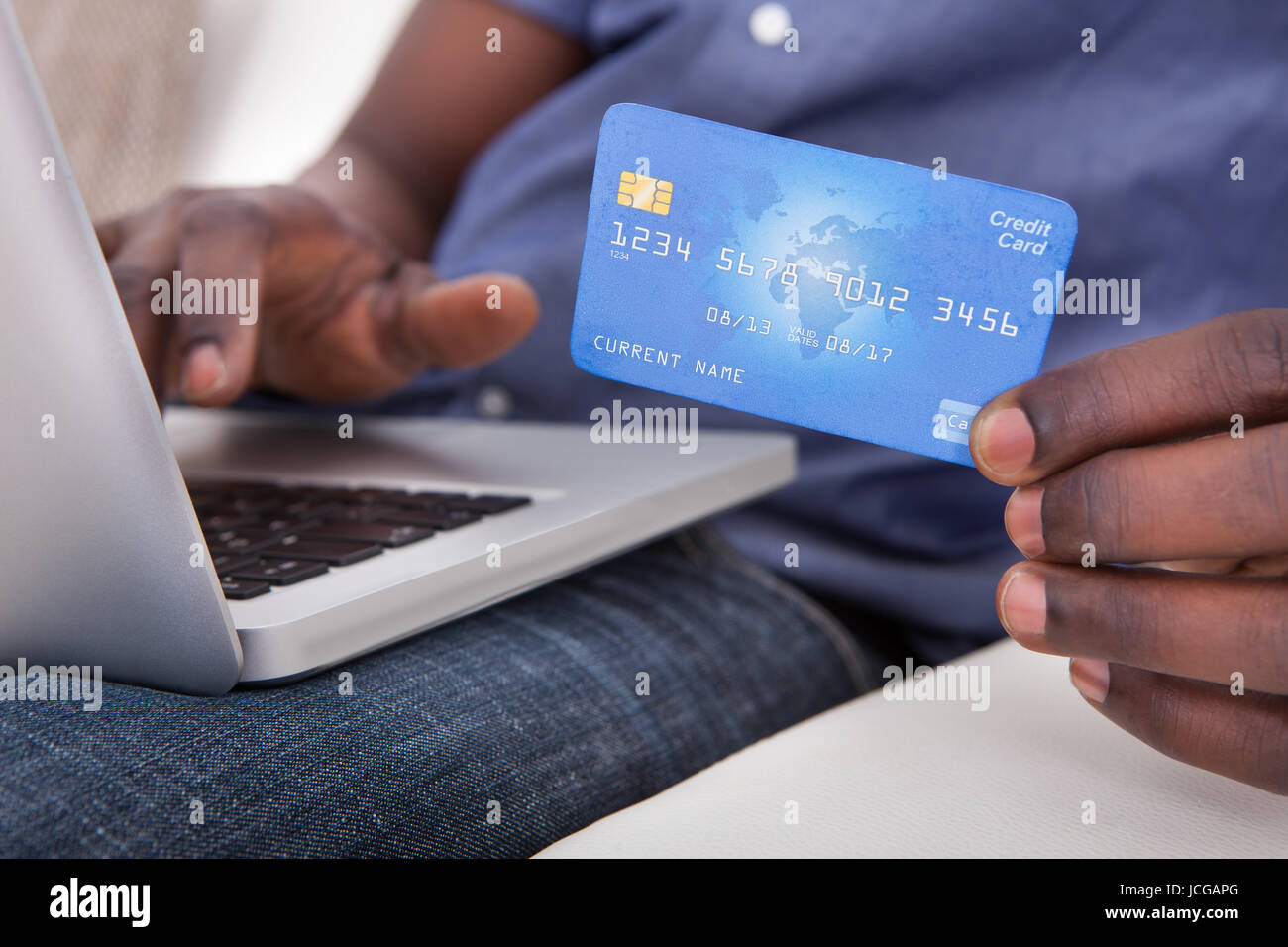 Close-up Of Hand Holding Laptop With Credit Card Stock Photo - Alamy