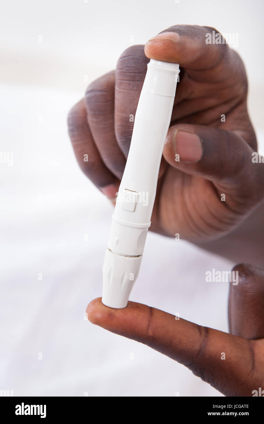 Close-up Of Hand Holding Glucometer Over White Background Stock Photo ...