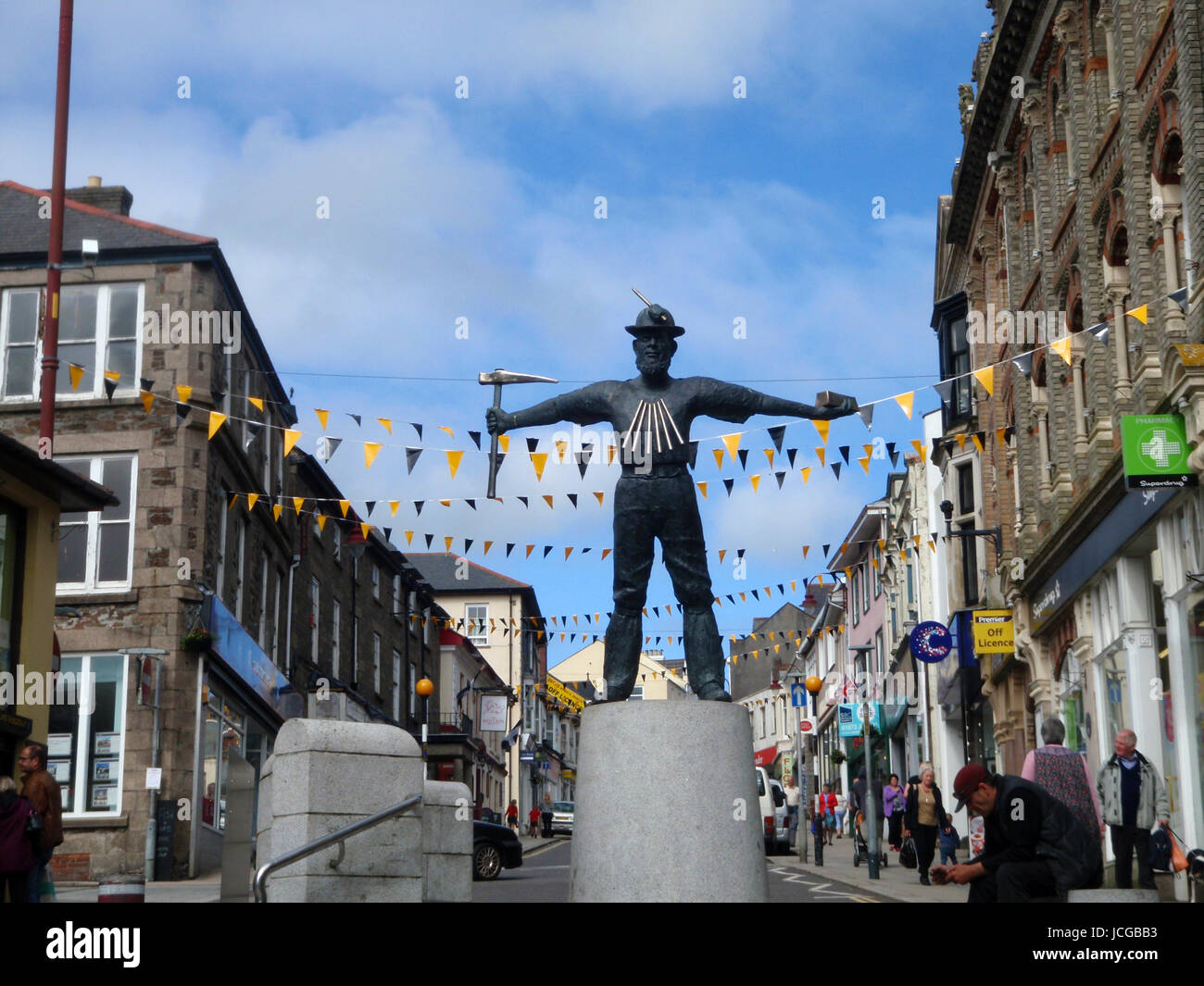 Bronze statue of a Cornish miner with outstretched hands holding an axe ...