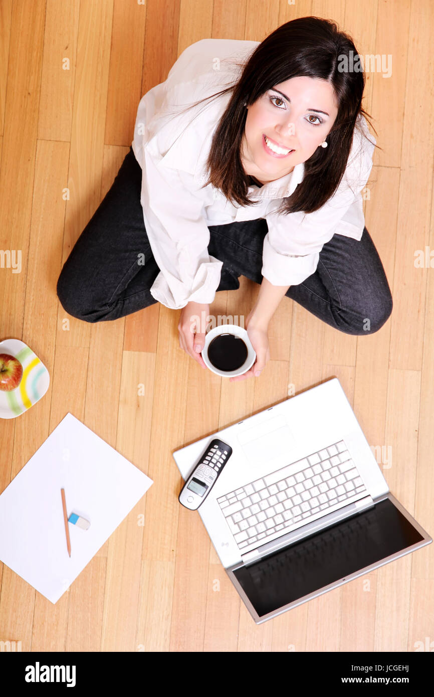 A young adult woman studying on the floor Stock Photo - Alamy