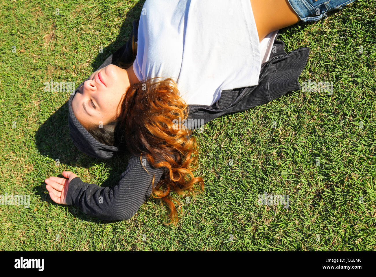 A young woman enjoying the sunlight in the Park Stock Photo - Alamy