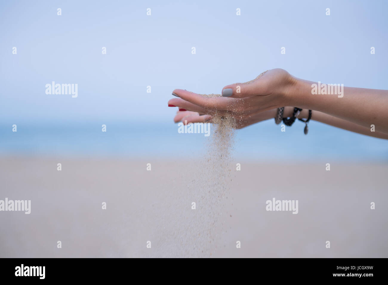 Hand holding down the sand Stock Photo - Alamy