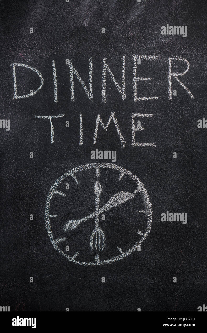 Dinner time text with clock drawn with white chalk on blackboard Stock ...