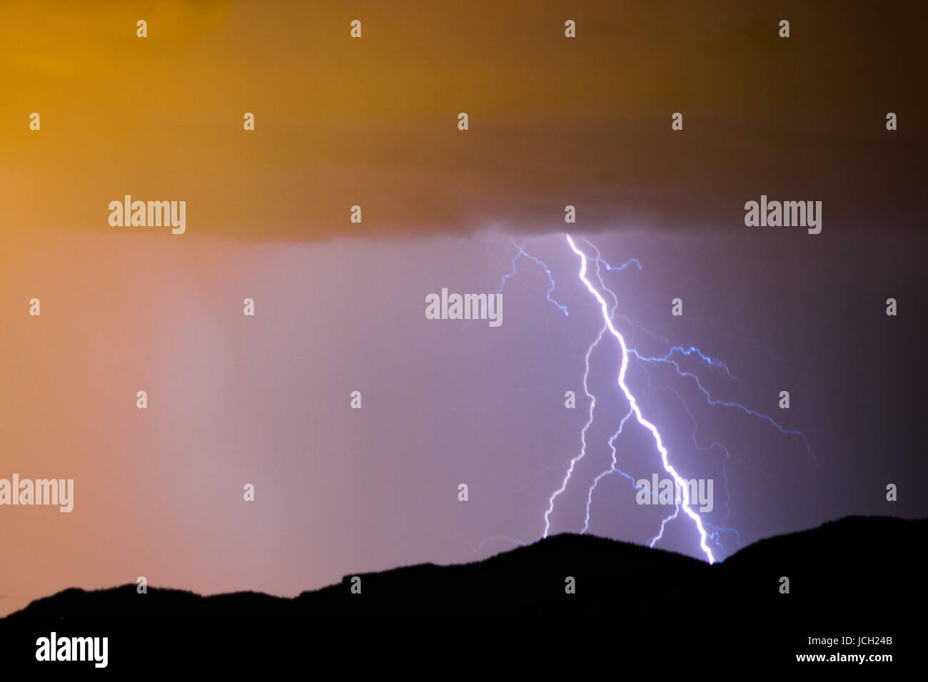 Lightning striking behind the mountains near Tucson during monsoon ...