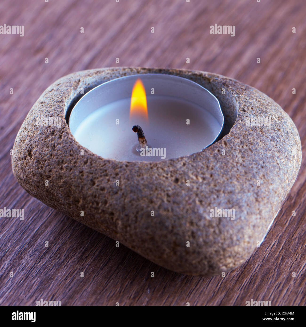 Lit candle inside a stone for decoration Stock Photo - Alamy