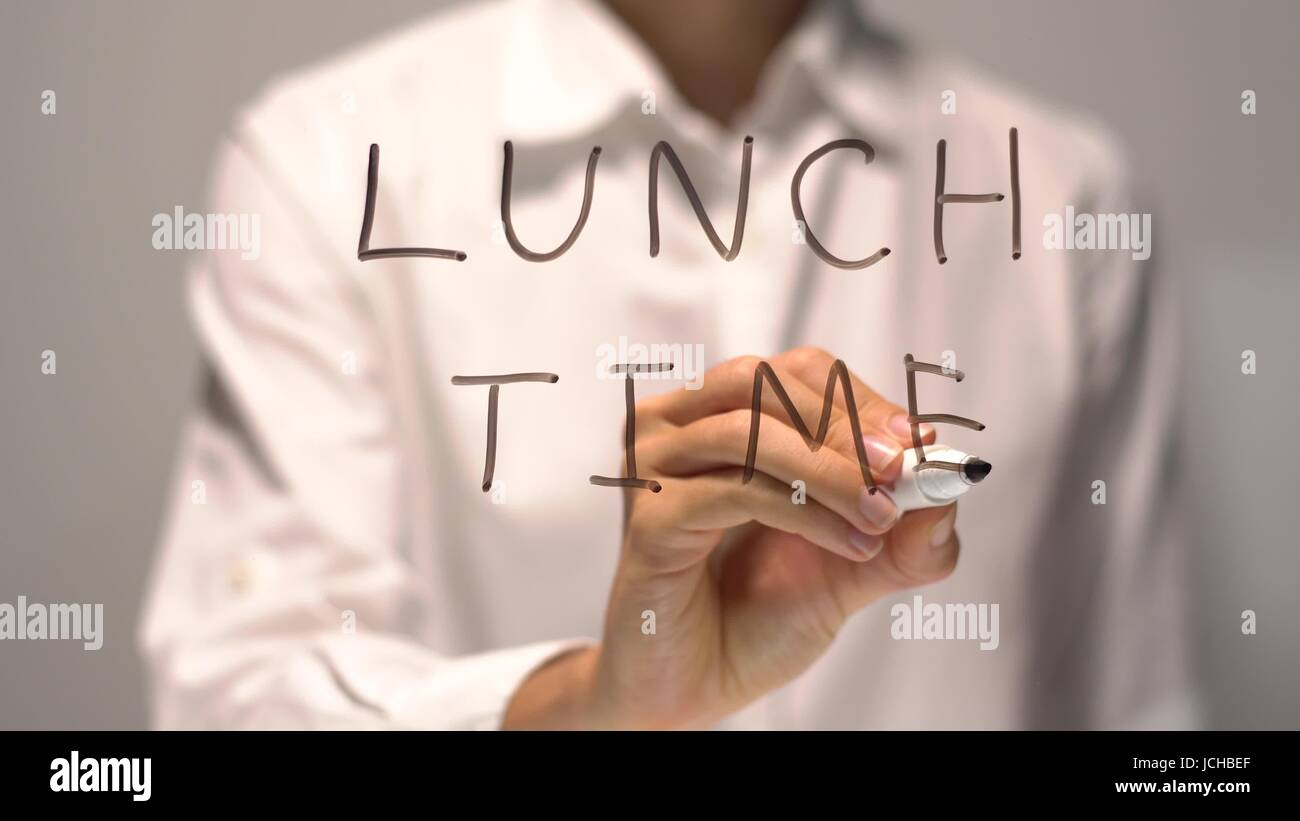 Woman writing Lunch Time on transparent screen. Businesswoman write on ...