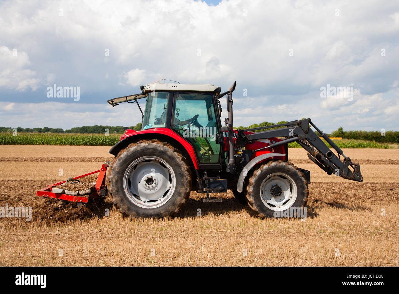 Tractor with plow in the field Stock Photo - Alamy