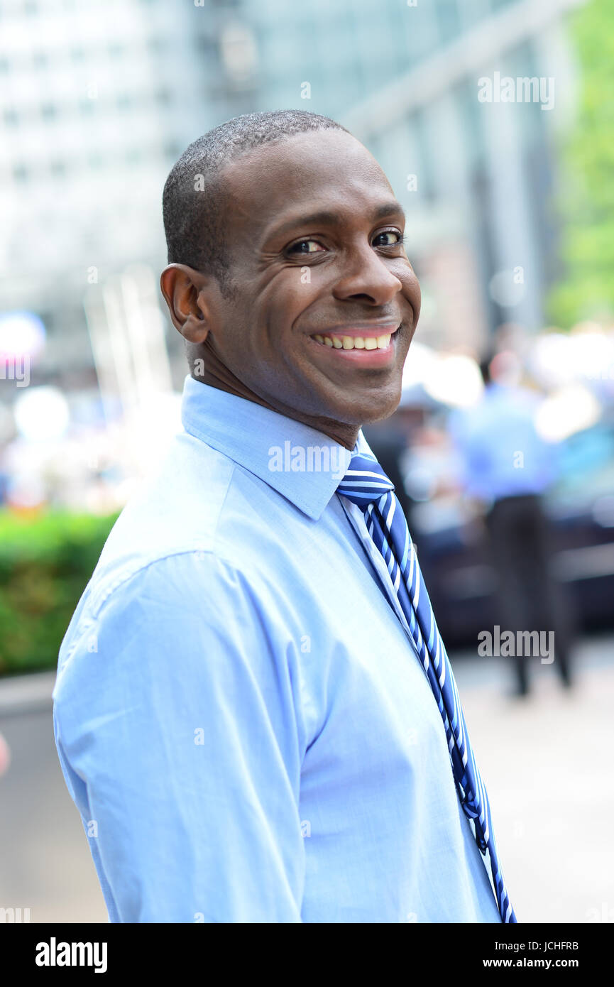 Businessman standing in front of his office building Stock Photo - Alamy