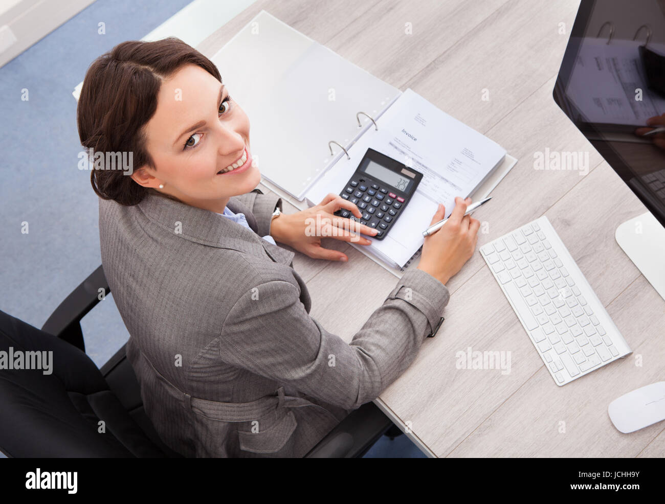 Portrait Of Smiling Young Female Accountant Calculating Bills Stock ...