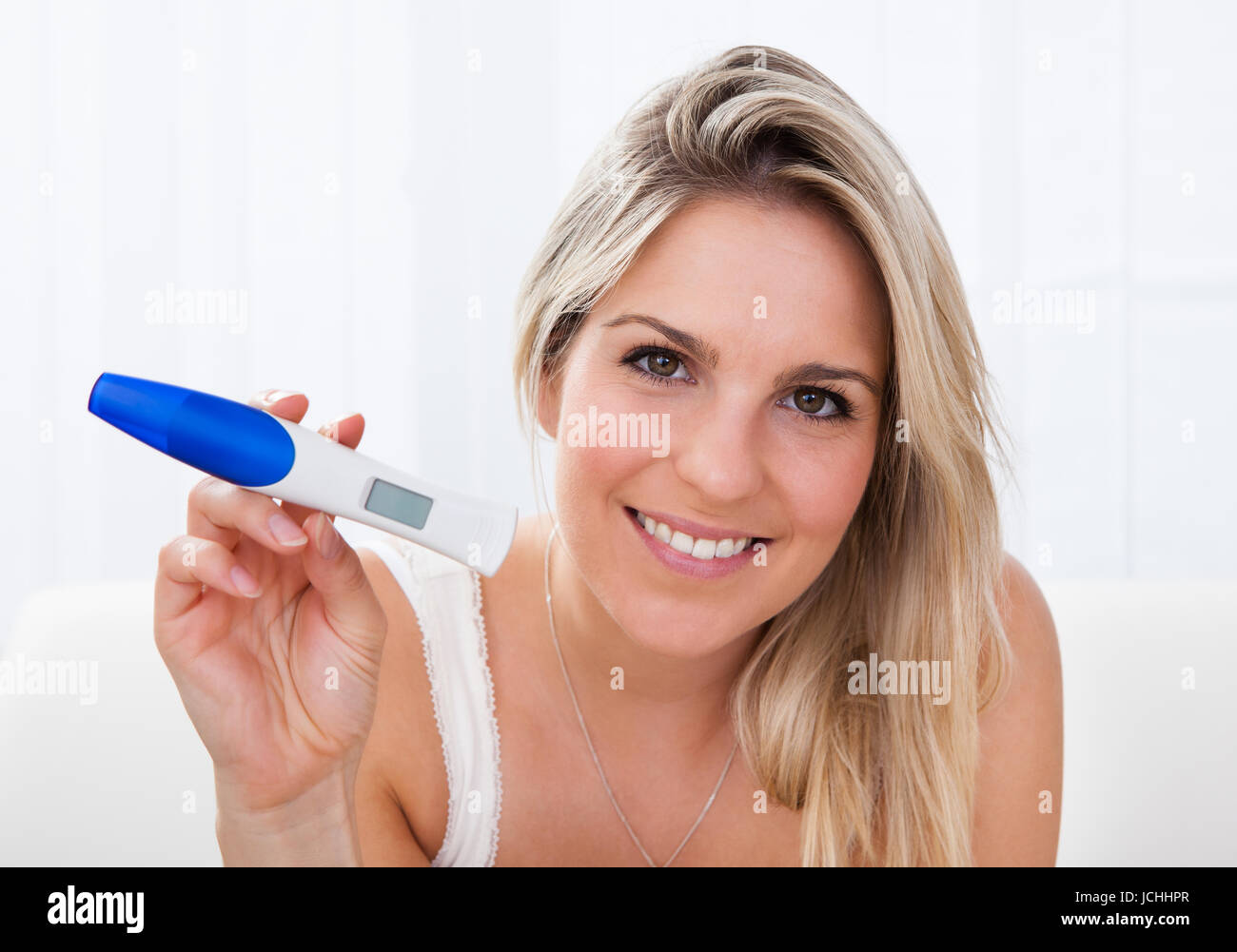 Portrait of a happy young woman holding positive pregnancy test Stock ...