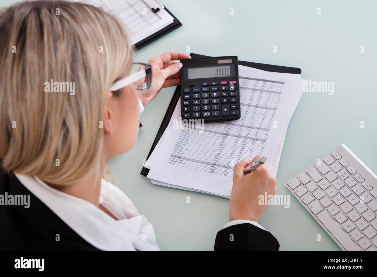Young Businesswoman Calculating Data In Her Office Stock Photo - Alamy