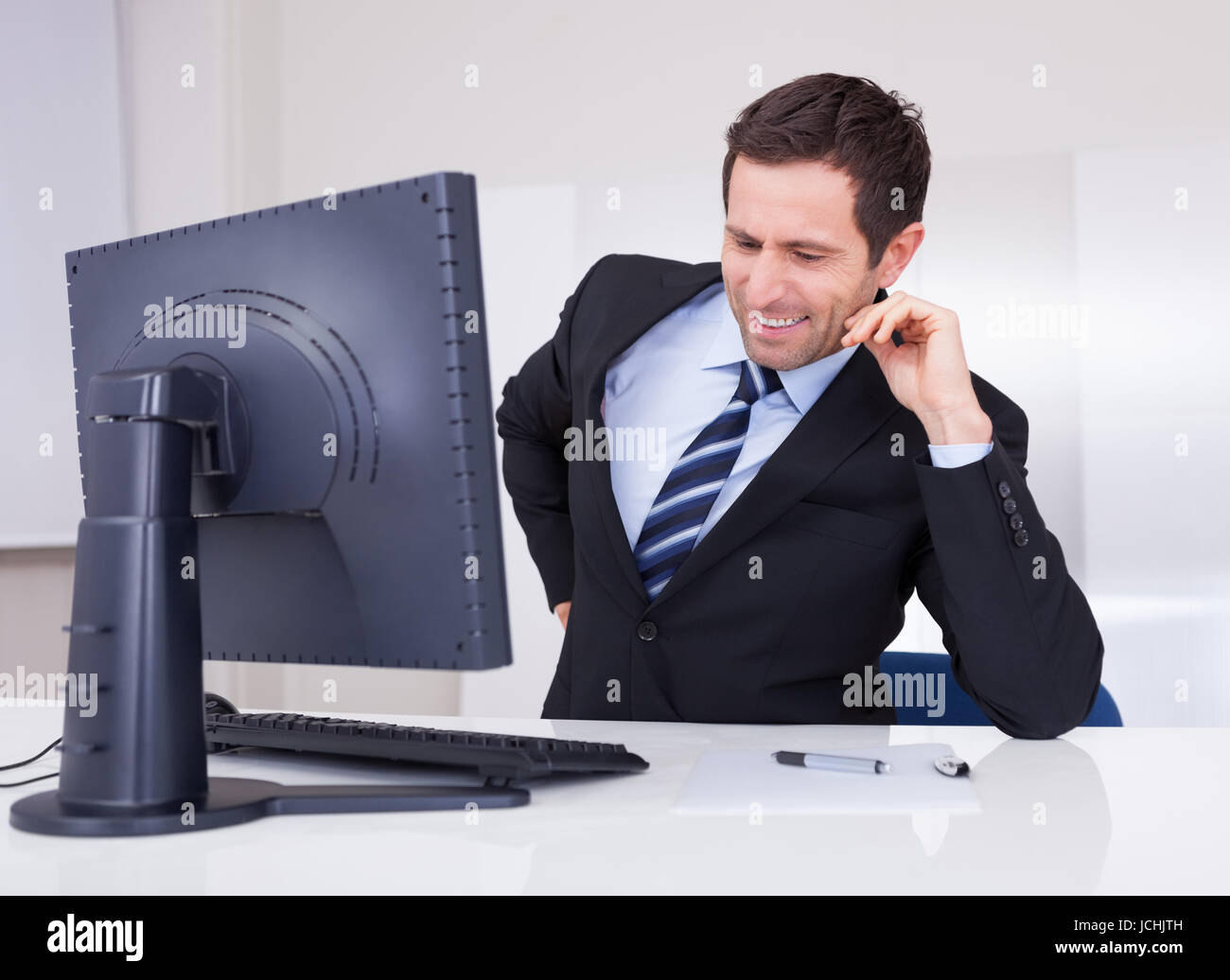 Portrait Of Happy Businessman Using Computer At Workplace Stock Photo ...