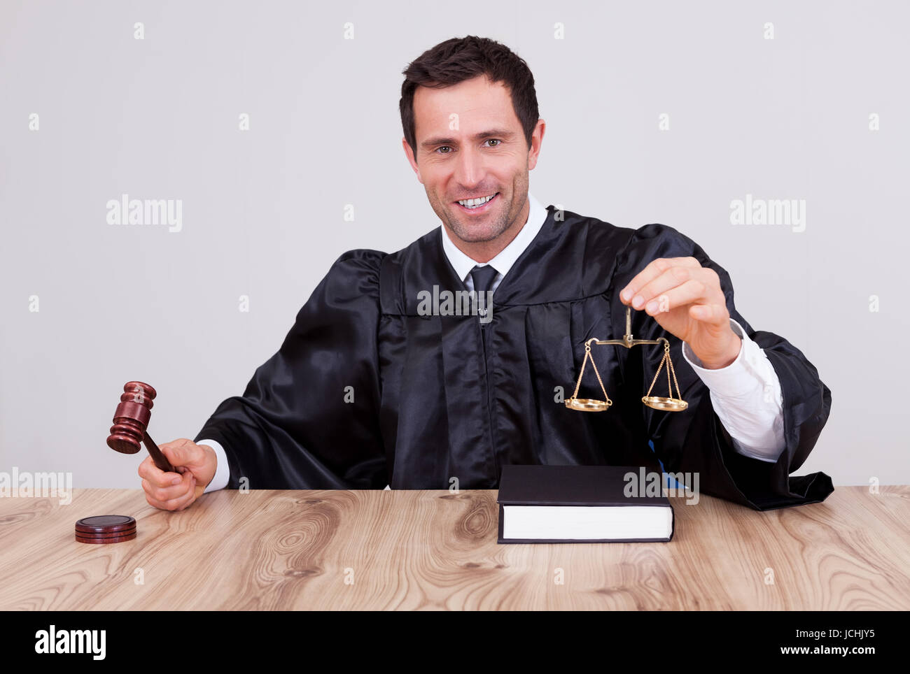 Male Judge Holding Gavel and Scale In Courtroom Stock Photo - Alamy