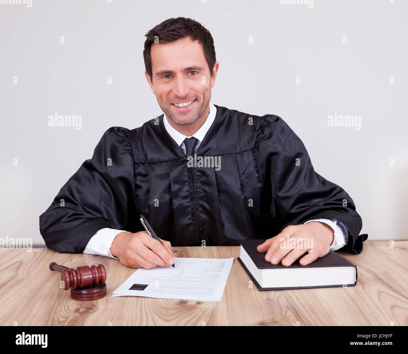 Male Judge Writing On Paper In Courtroom Stock Photo - Alamy